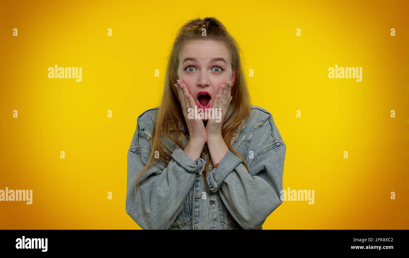 Cheerful teen girl raising hands in surprise shocked by sudden victory ...