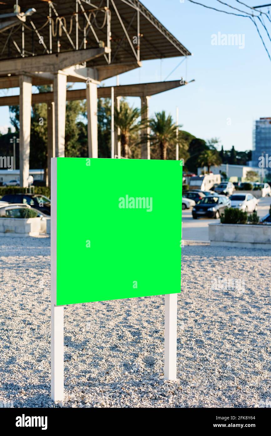 Blank square road sign on the beach against the background of a car ...