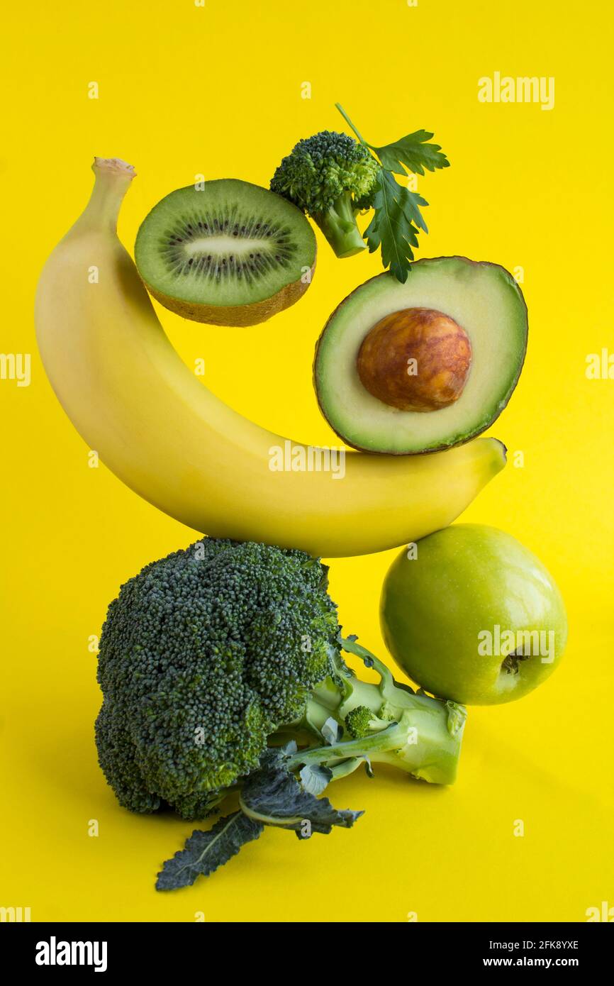 Pyramid of vegetable and fruit in balance on the yellow background ...