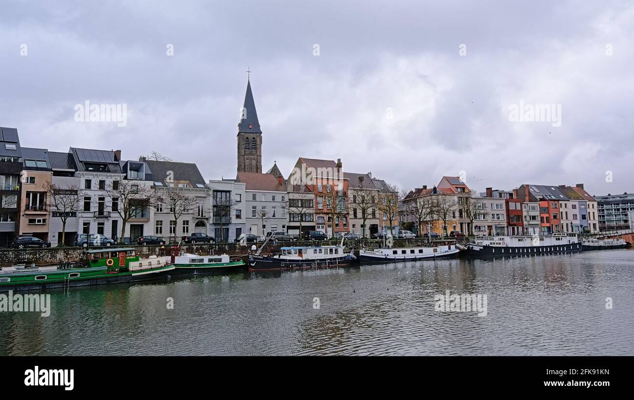 River Lys with houseboats and quay with houses and church on a cloudy ...