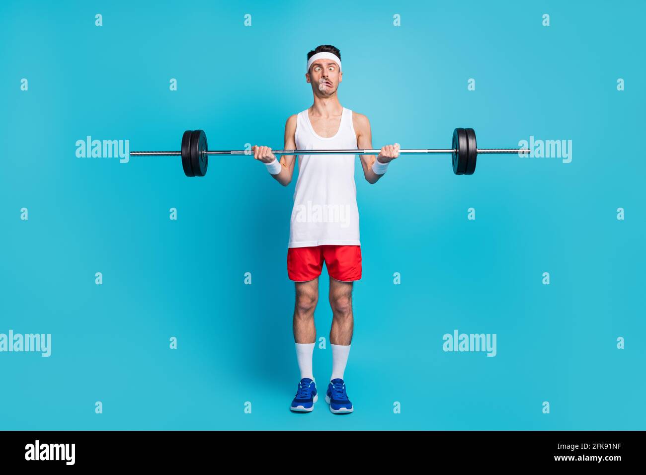 Photo of young sportsman lift heavy barbell grimacing exercise bodycare ...