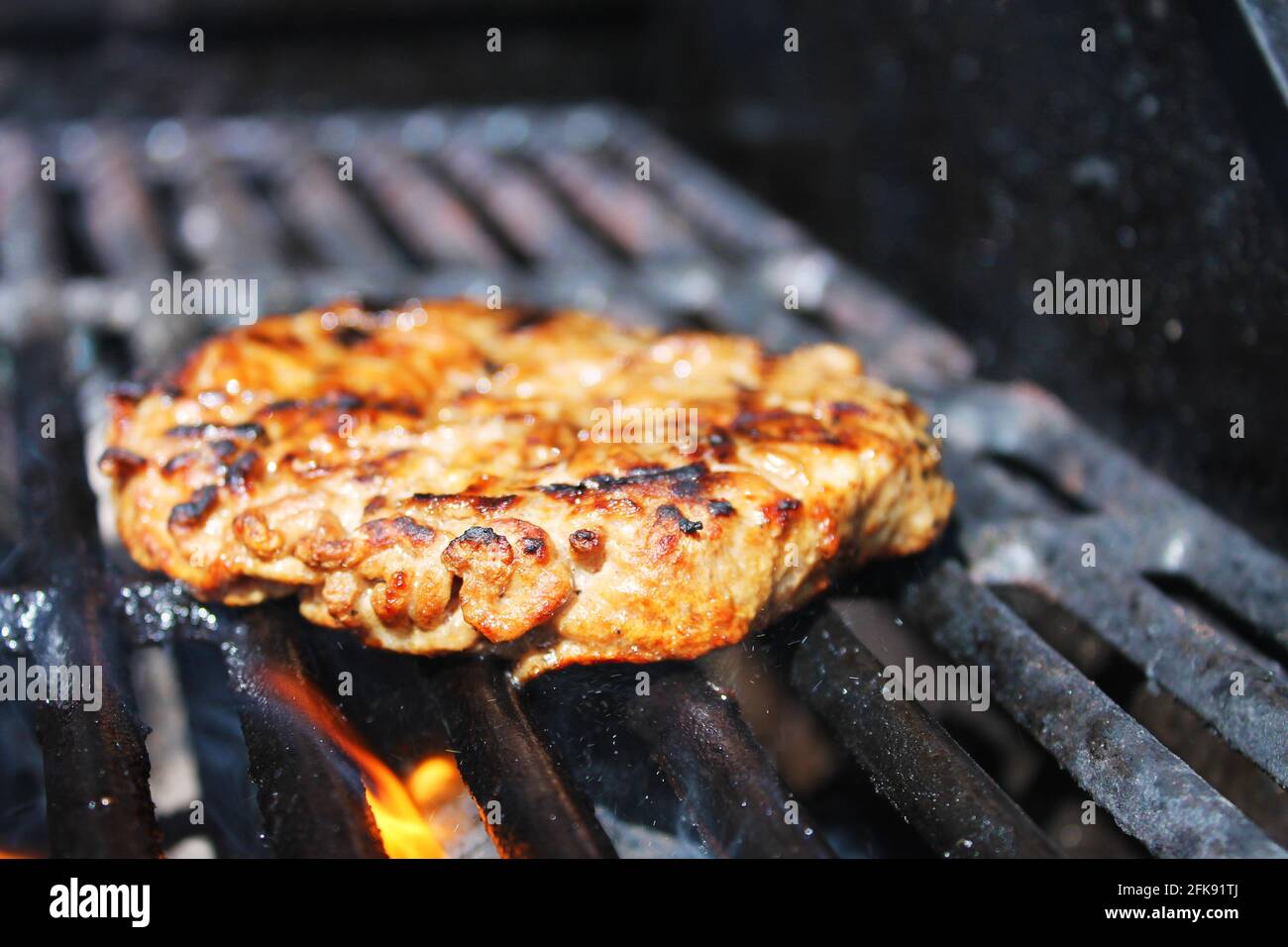 Close-up of a hamburger patty cooking on a barbecue grill Stock Photo ...