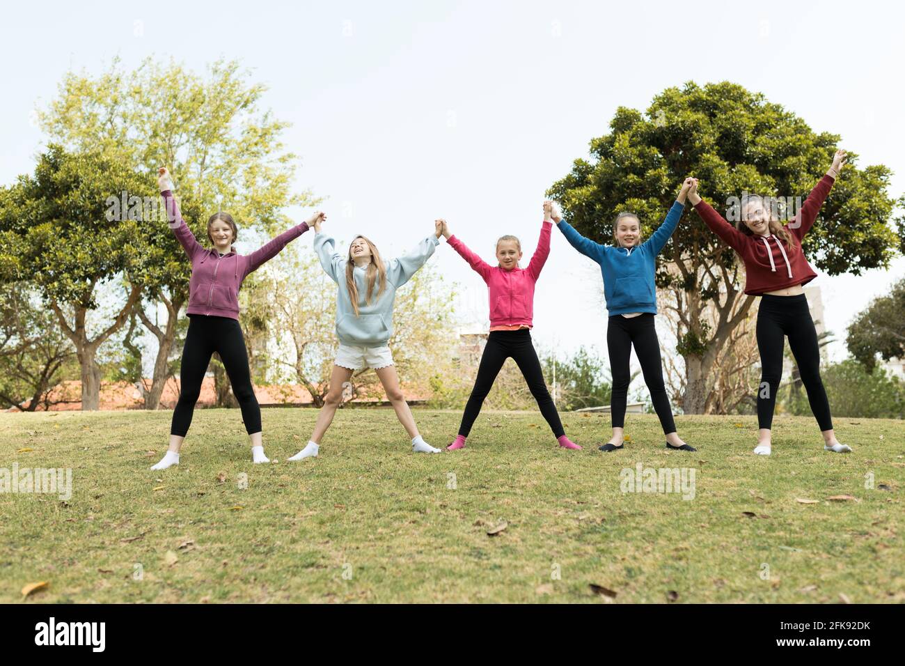 Group of happy girls smiling and show unity Stock Photo - Alamy