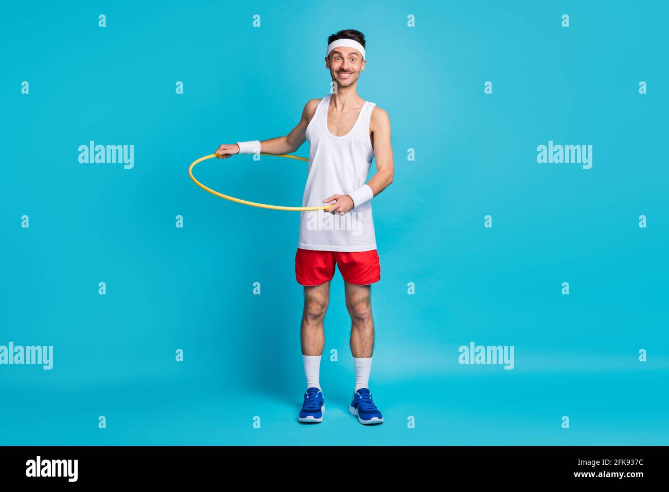 Photo of young excited man happy smile spin plastic circle around waist ...
