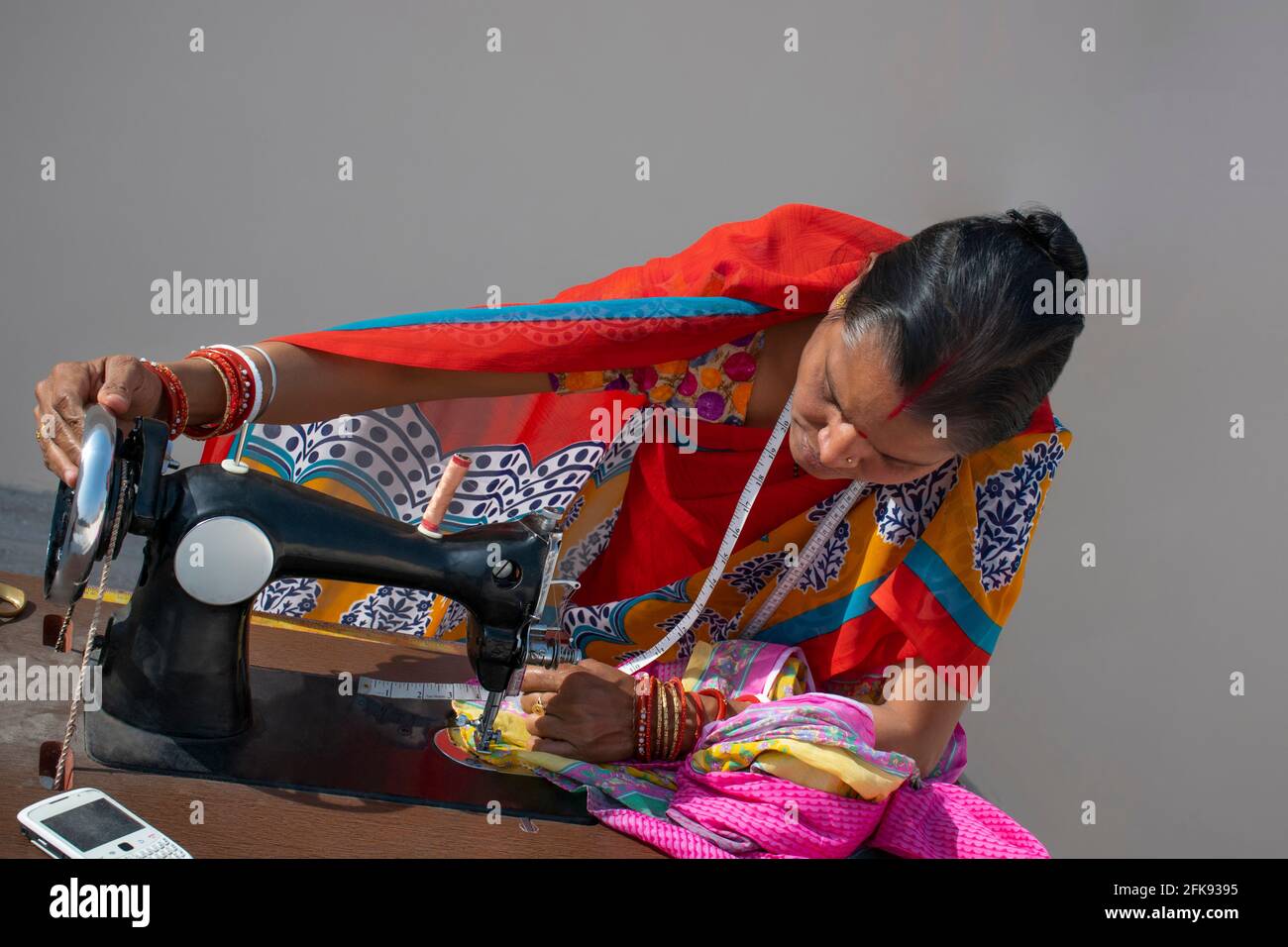 Indian woman stitching cloths by machine in rural India Stock Photo - Alamy