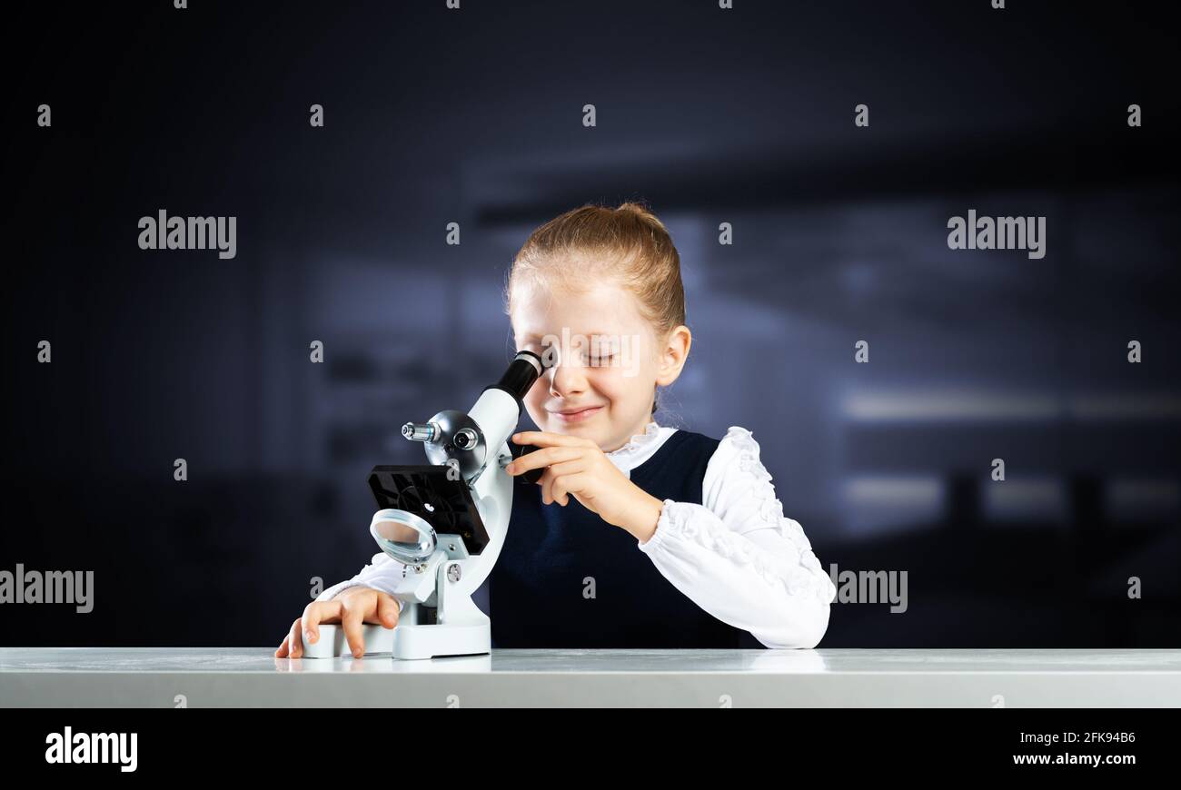 Little scientist looking through microscope Stock Photo - Alamy