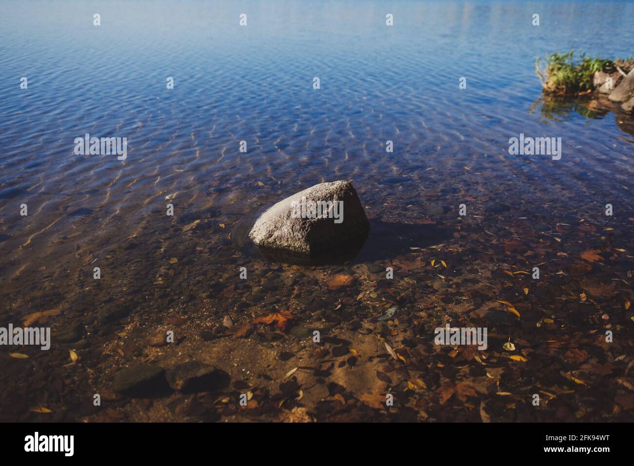 stone in the blue lake. autumn landscape Stock Photo - Alamy