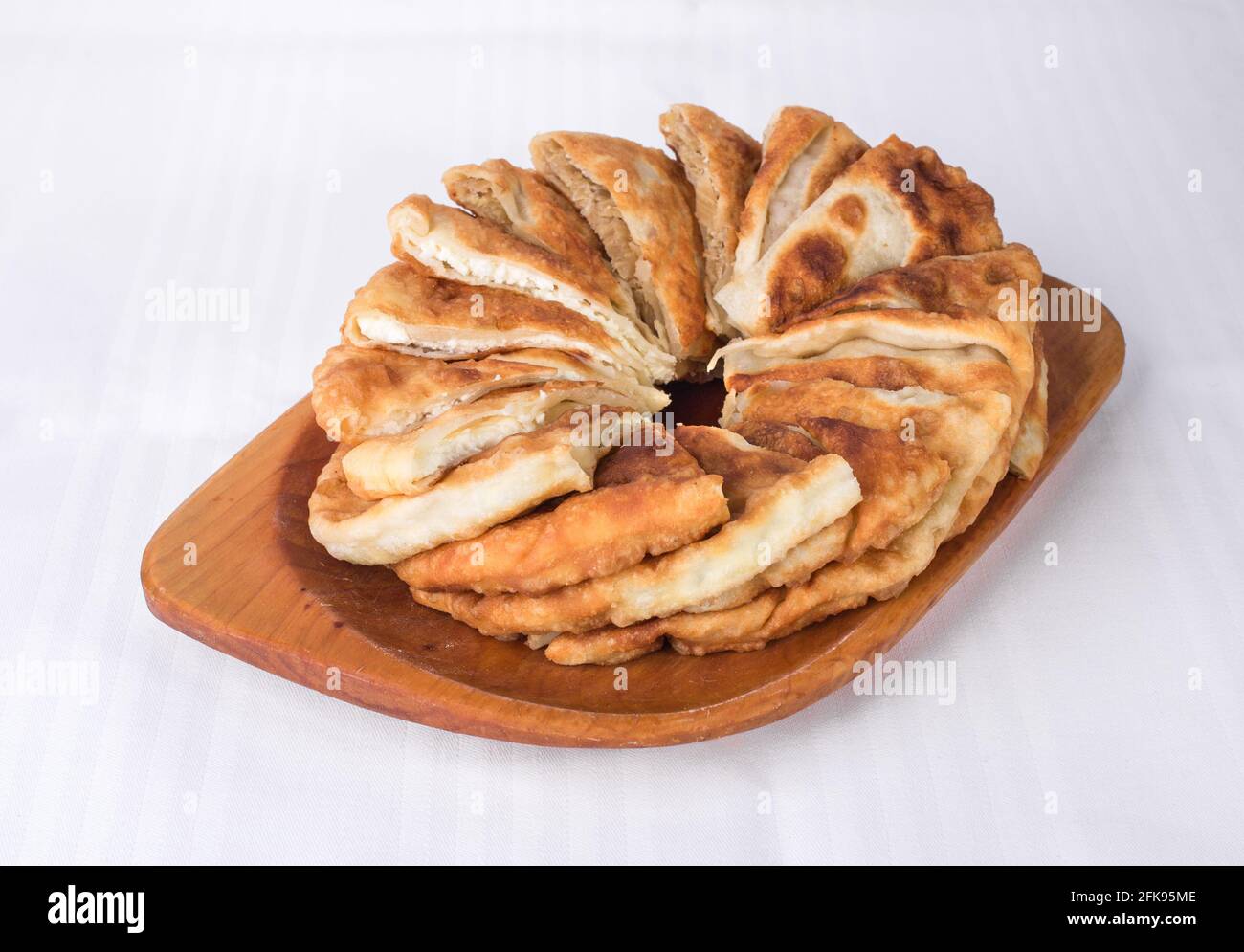 Delicious sliced puff pie with curd cheese and cabbage. Wooden platter ...