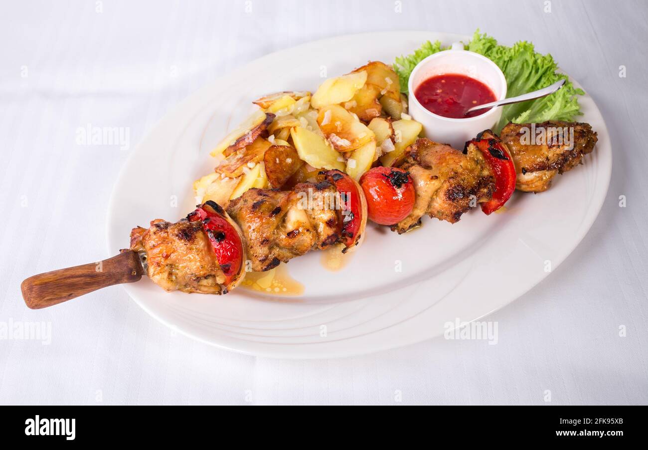 Grilled chicken shish kebab with roasted potatoes and delicious red ...