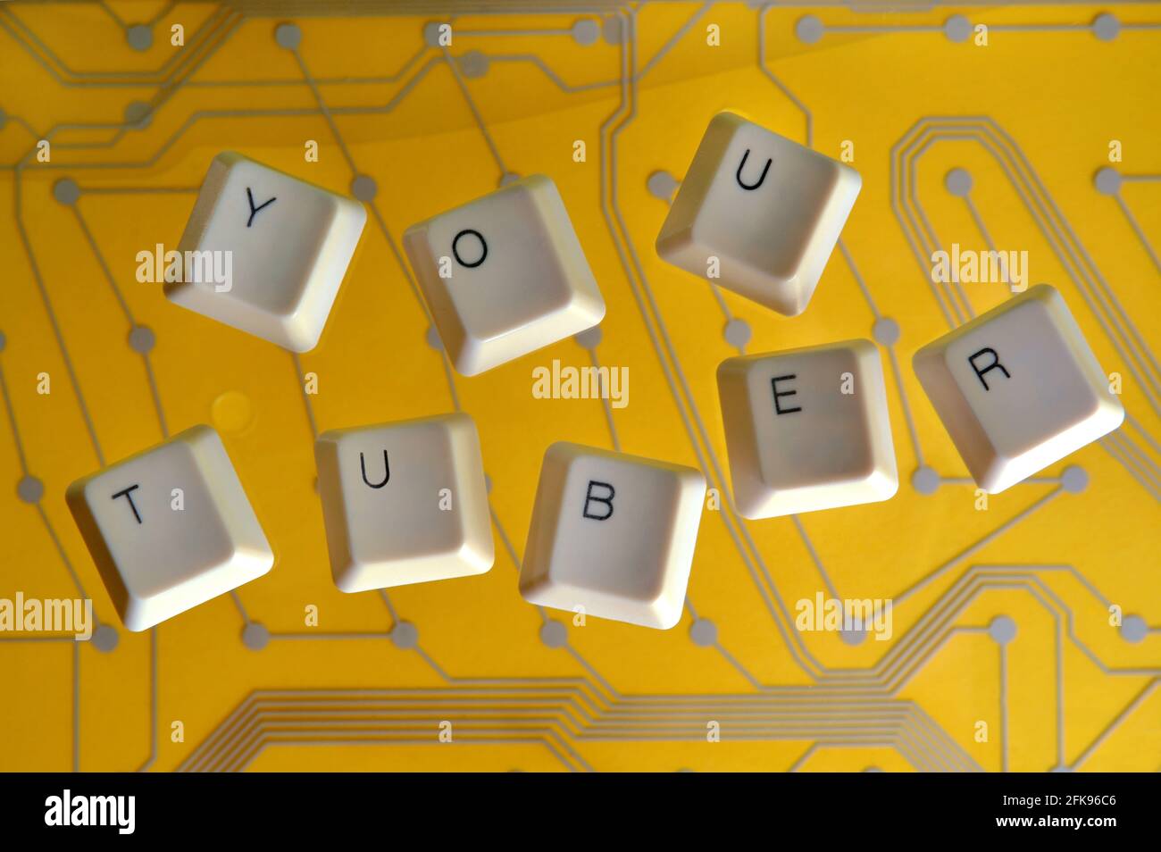 Keyboard keys form the word YOU TUBER on yellow electric circuit in the ...