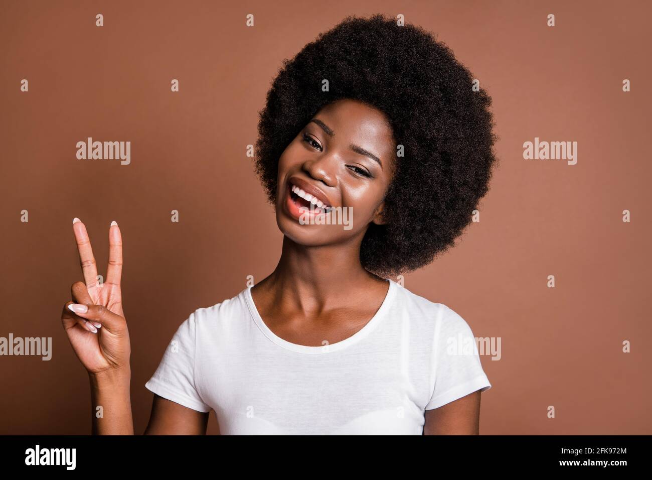 Photo of adorable positive dark skin person fingers show v-sign toothy ...