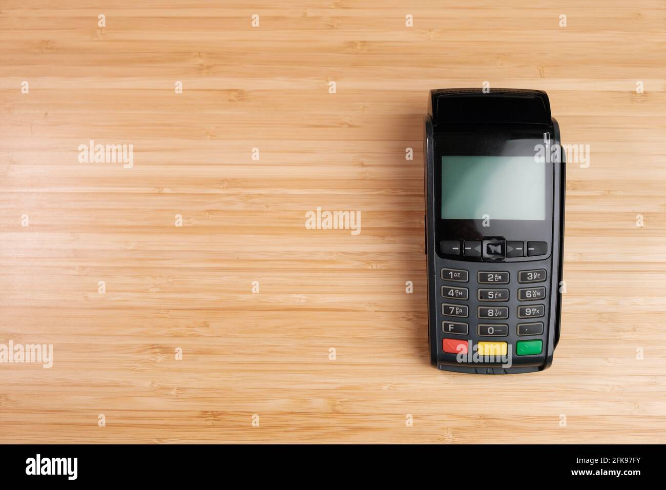 POS terminal on the wooden desk with copy space. Contactless payment ...