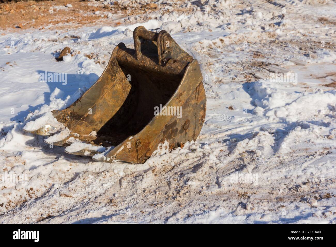 Removable excavator bucket against the background of white snow ...