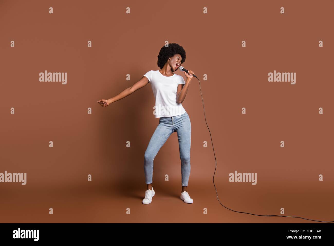 Full body photo of pretty positive dark skin lady hand hold mic singing ...