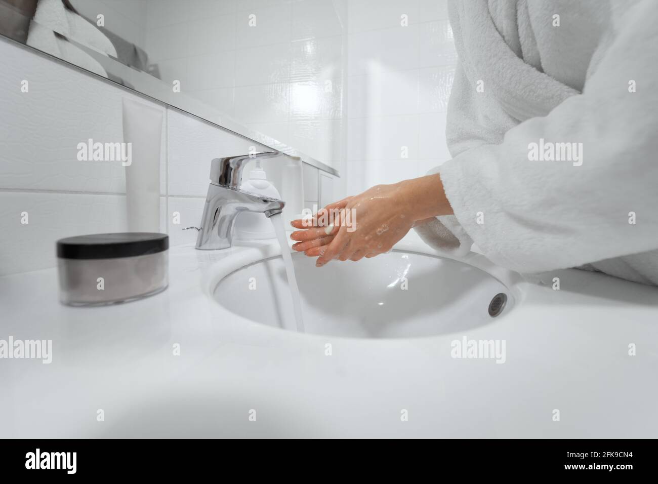 Side view of woman washing hands with antibacterial soap in modern ...