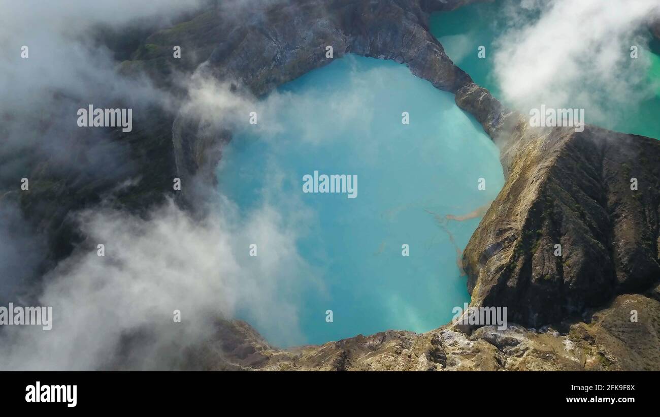 Clouds over volcanic lakes in the craters of Kelimutu volcano. Two of ...