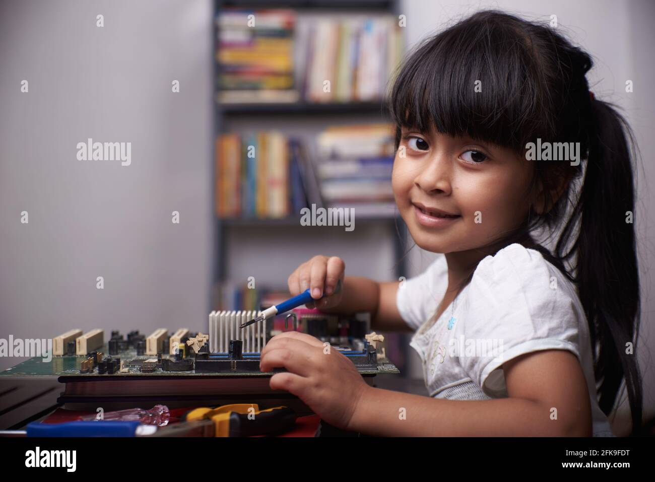 Little cute girl playing with broken computer part, kids creativity ...