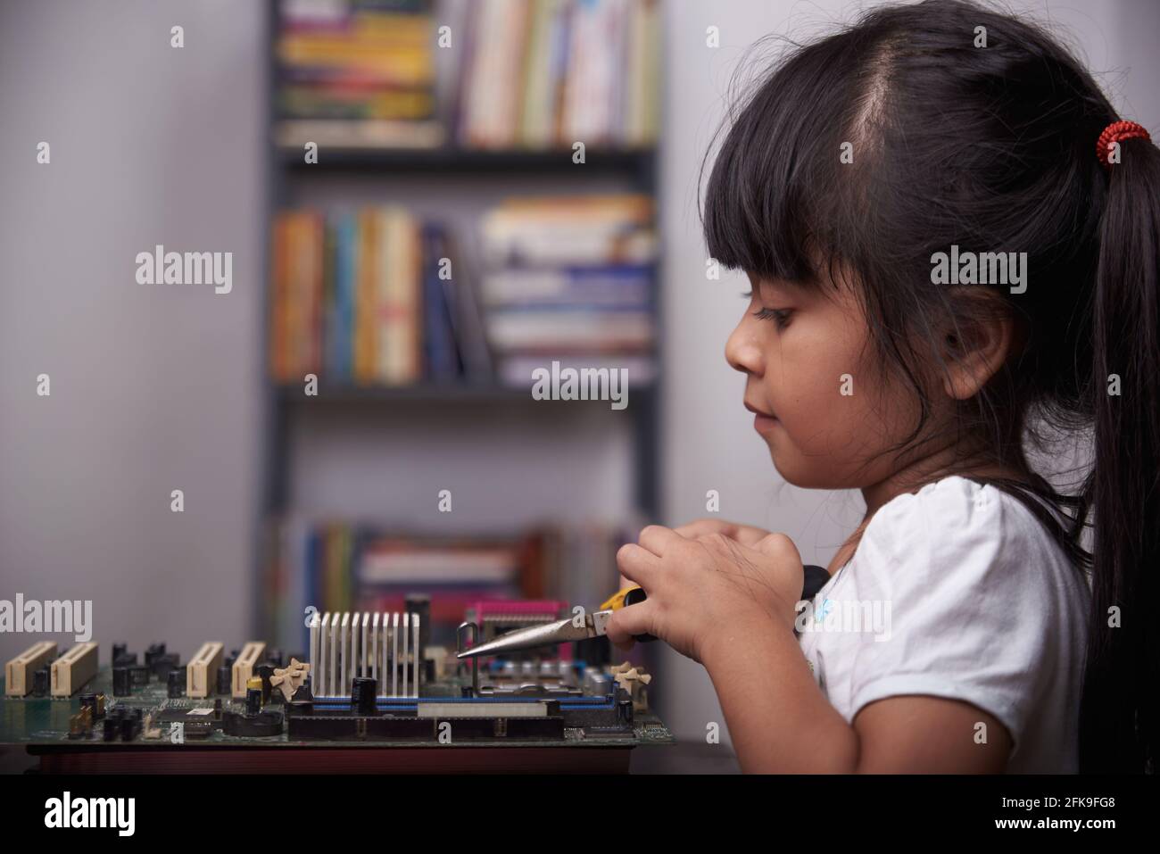 Little cute girl playing with broken computer part, kids creativity ...
