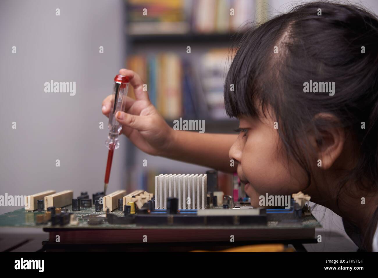 Little cute girl playing with broken computer part, kids creativity ...