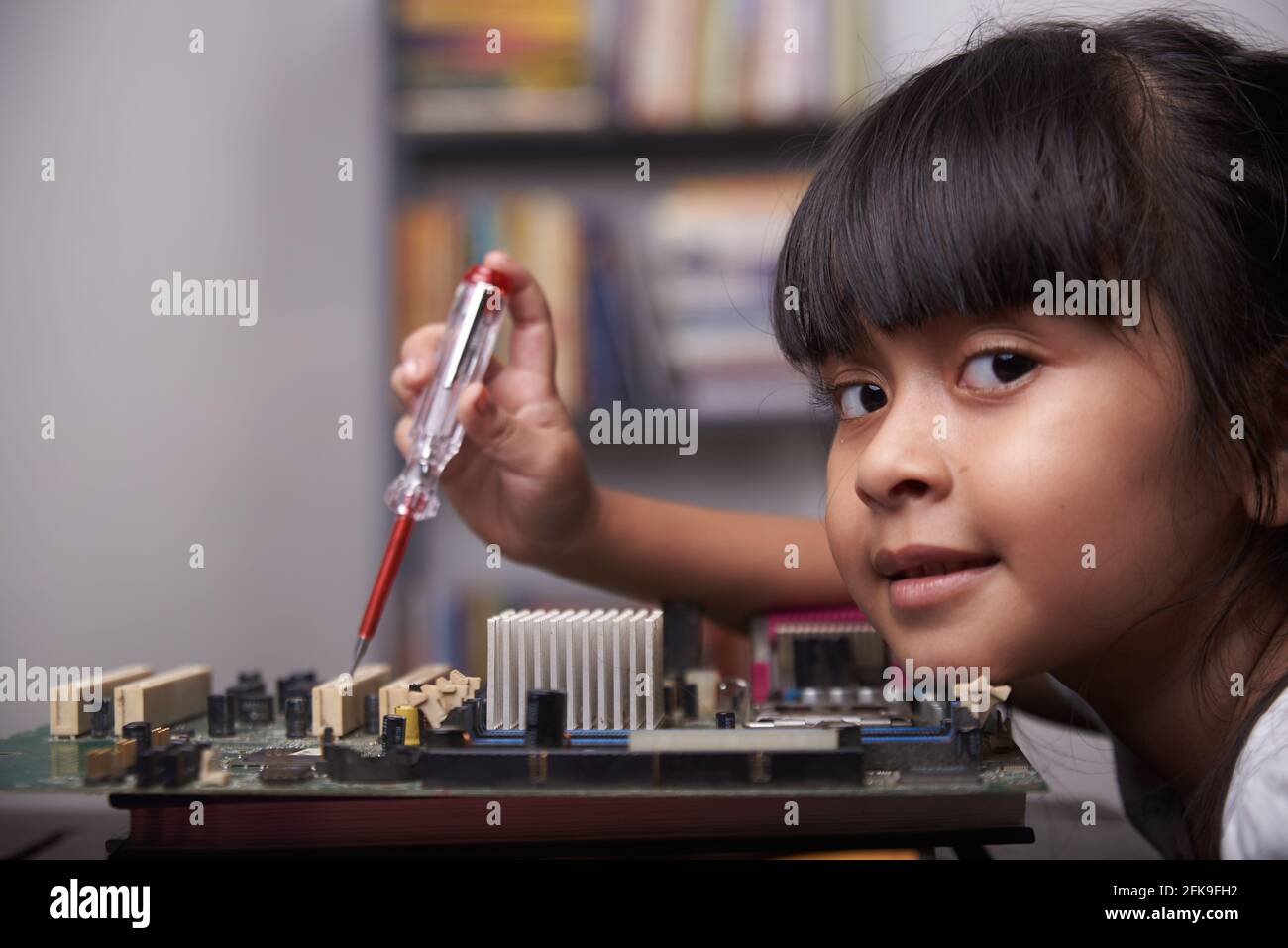 Little cute girl playing with broken computer part, kids creativity ...