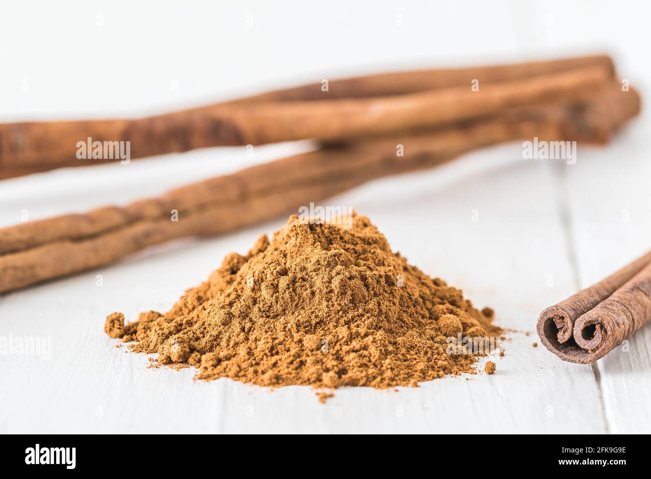 Close-up of cinnamon powder and cinnamon sticks on white wood Stock ...
