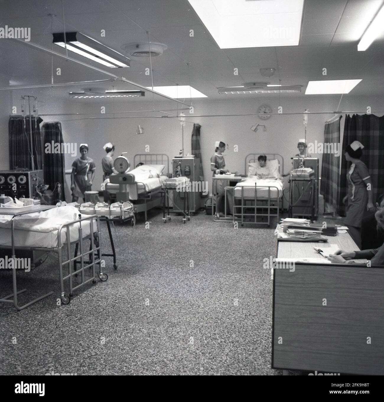 1970s, historical, inside a hospital ward showing nurses helping ...