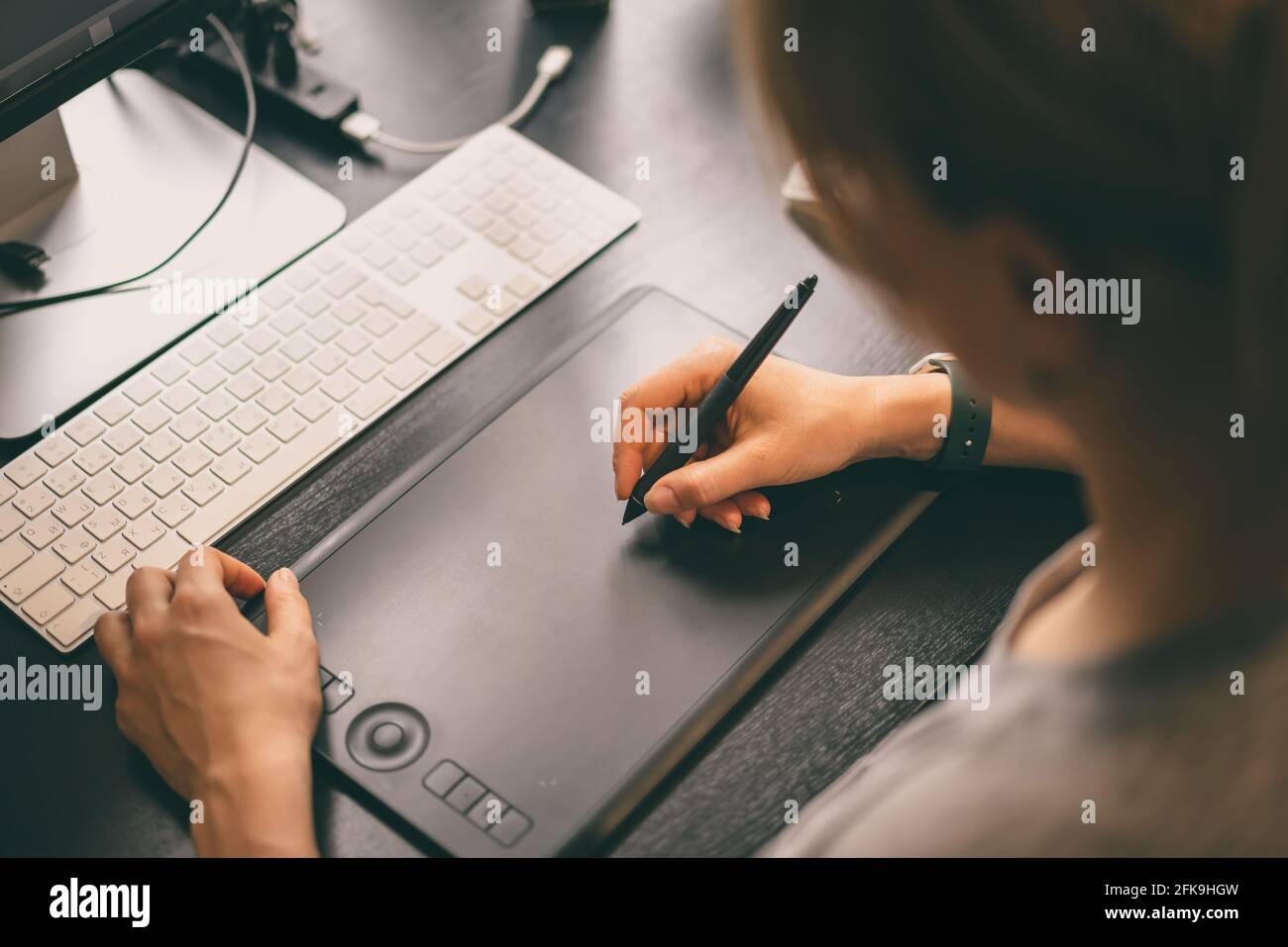 Woman designer, retoucher, photographer or artist drawing something on ...