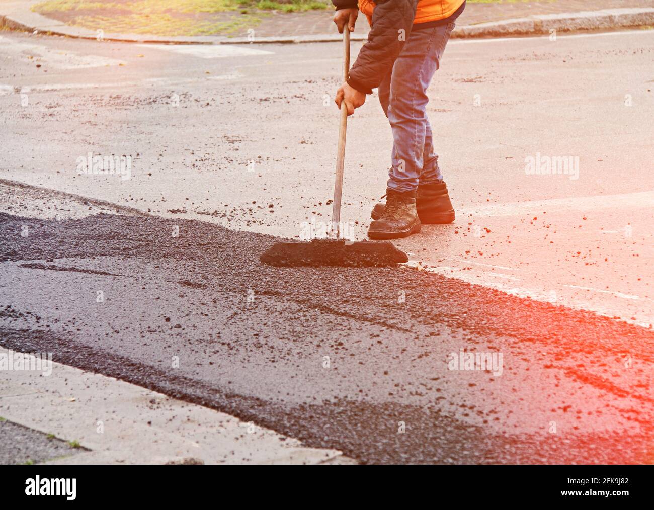 Man at work while paving the road Stock Photo - Alamy