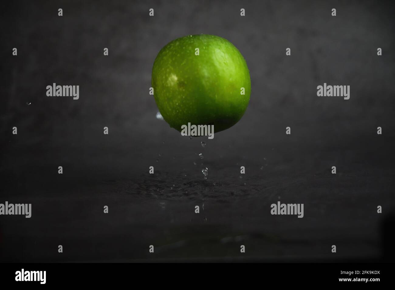 floating in the air green apple dark background Stock Photo - Alamy