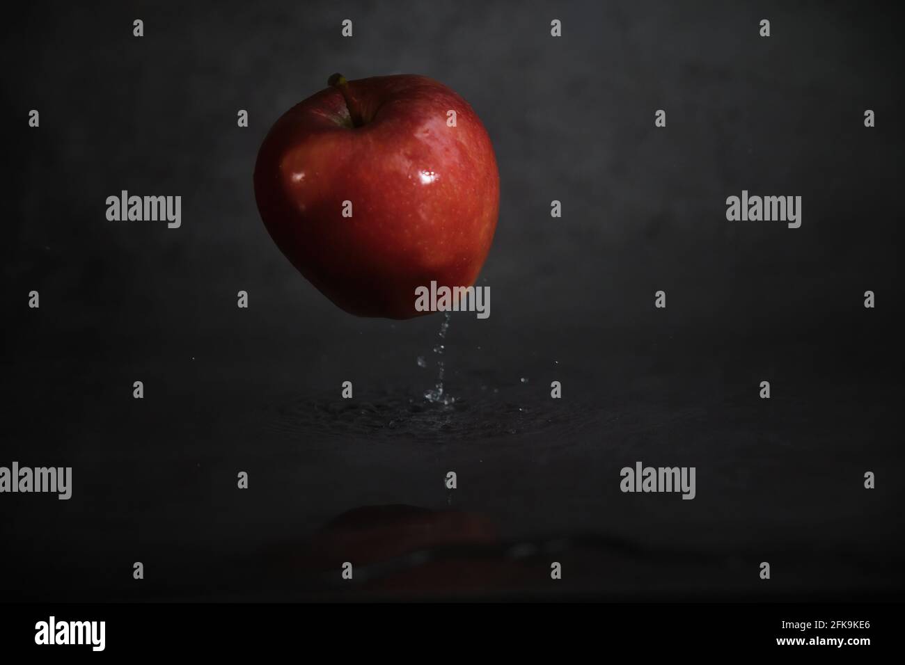 floating in the air red apple dark background Stock Photo - Alamy