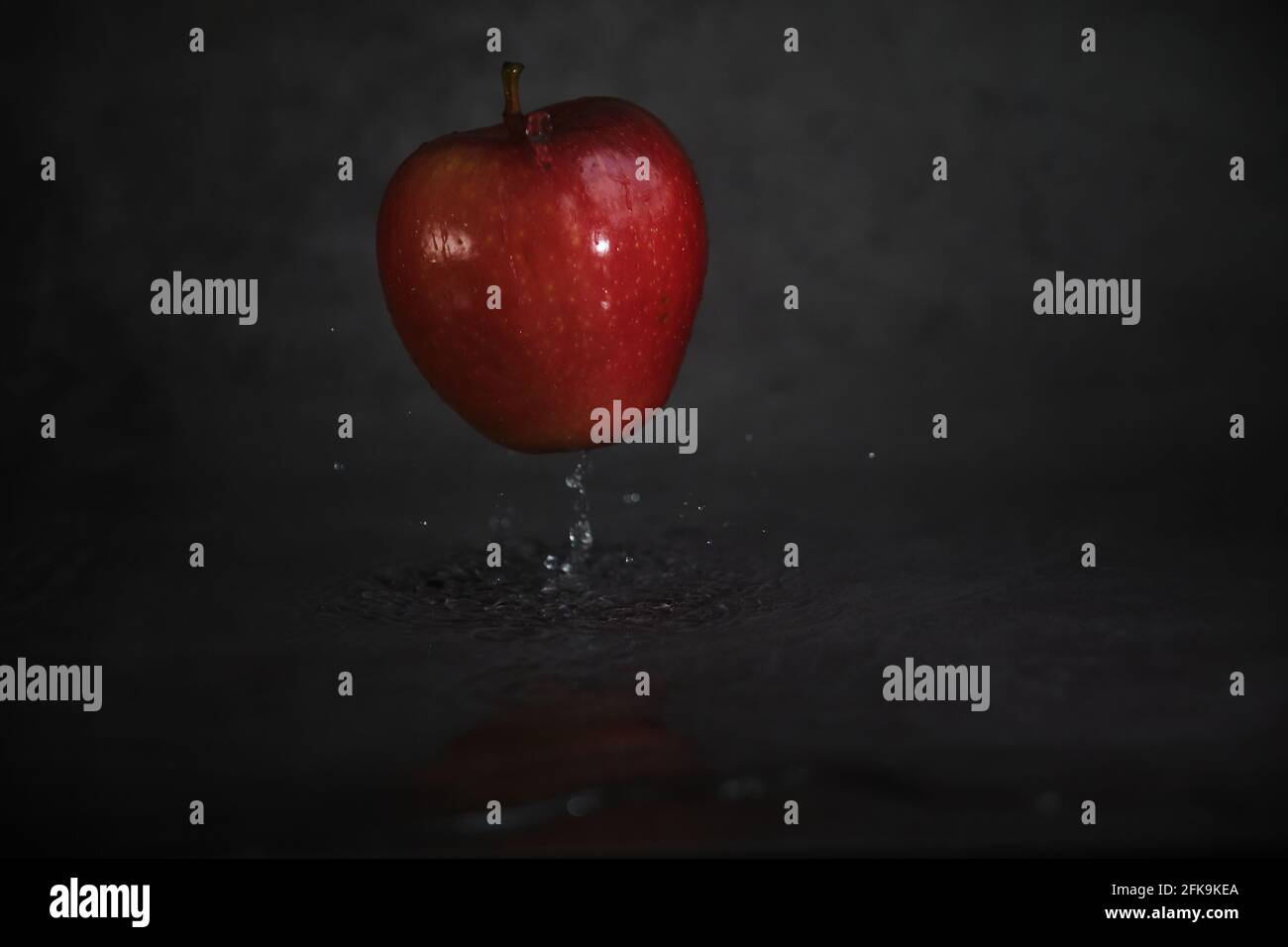 floating in the air red apple dark background Stock Photo - Alamy