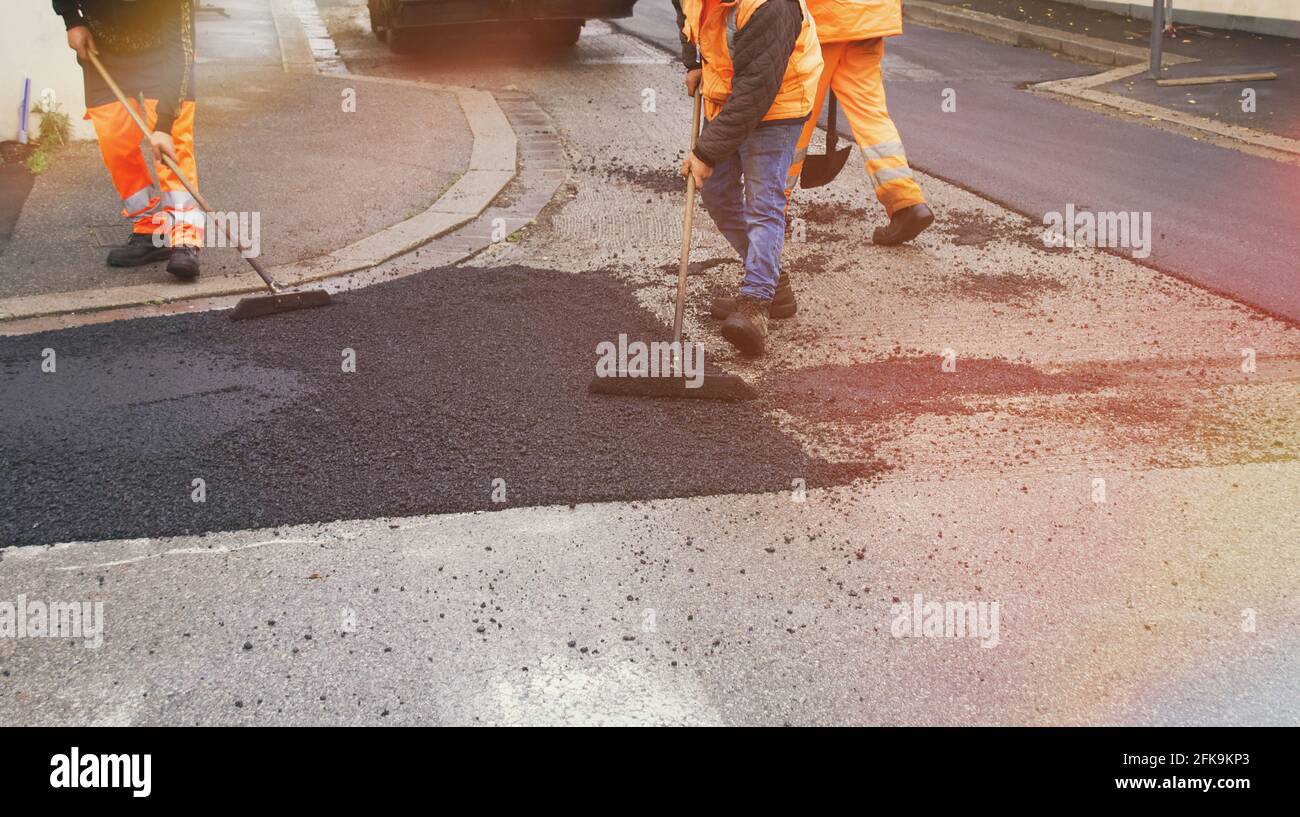 Man at work while paving the road Stock Photo - Alamy