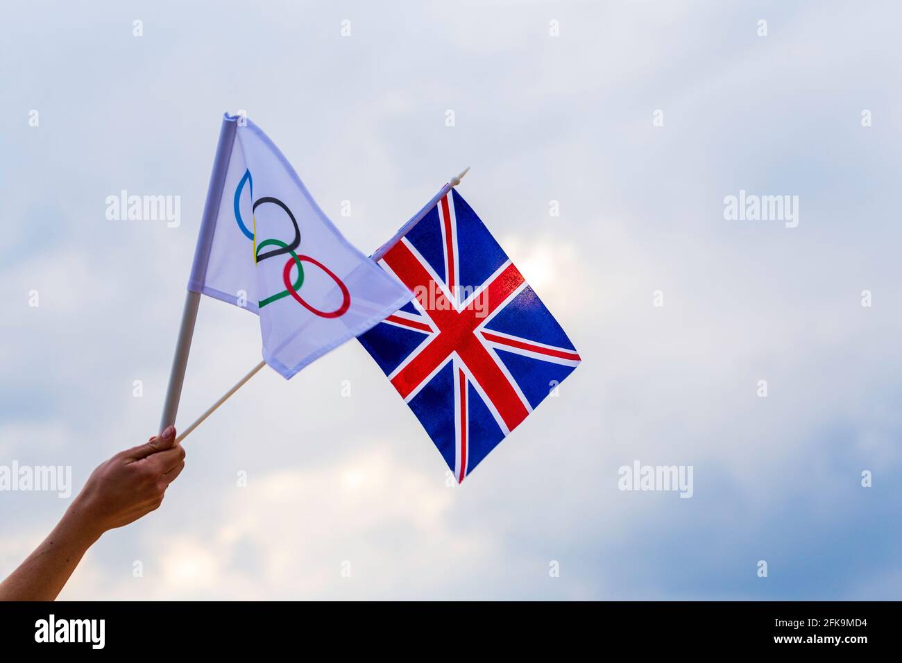 Fan waving the national flag of United Kingdom and the Olympic flag ...