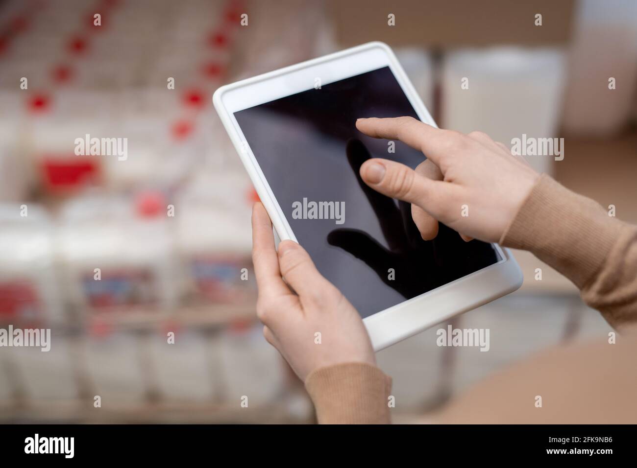 Close-up of unrecognizable manager using gadget while doing inventory ...