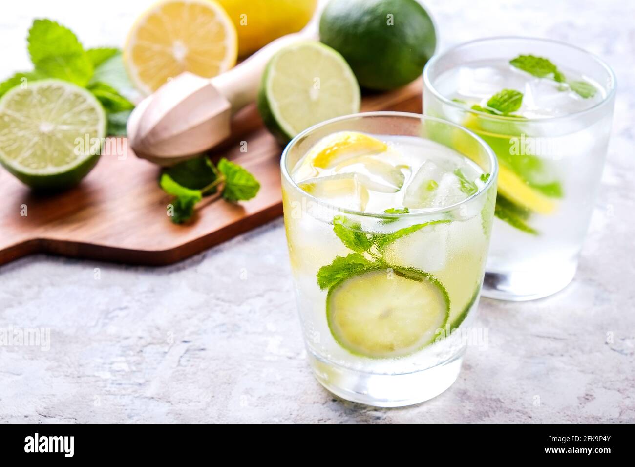 Two glasses of refreshing non alcoholic mojito lemonade drink with organic lemon, lime slices ...