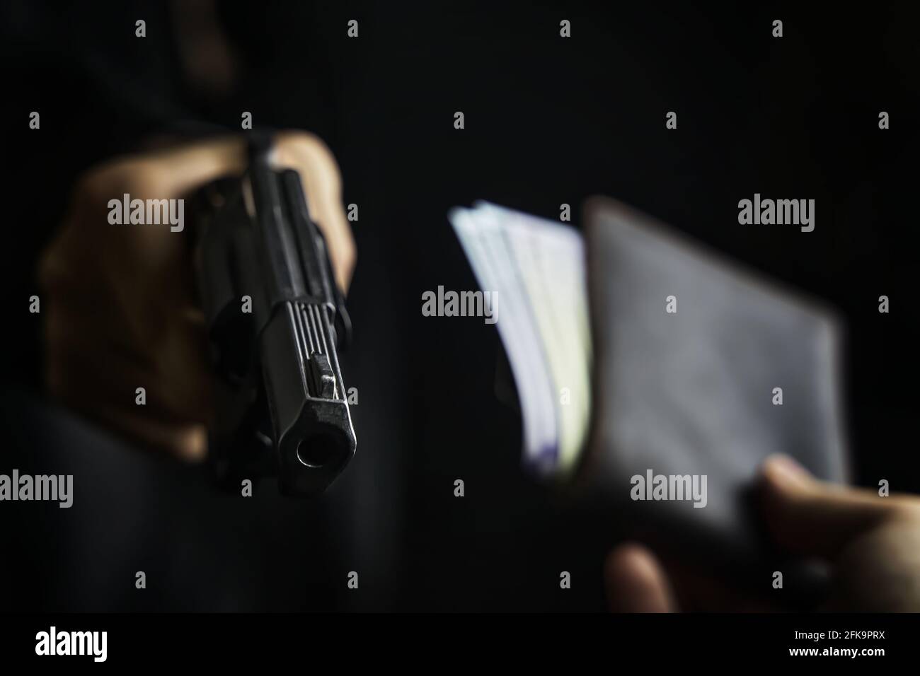 Revolver barrel and purse with money. Outstretched hand with wallet ...