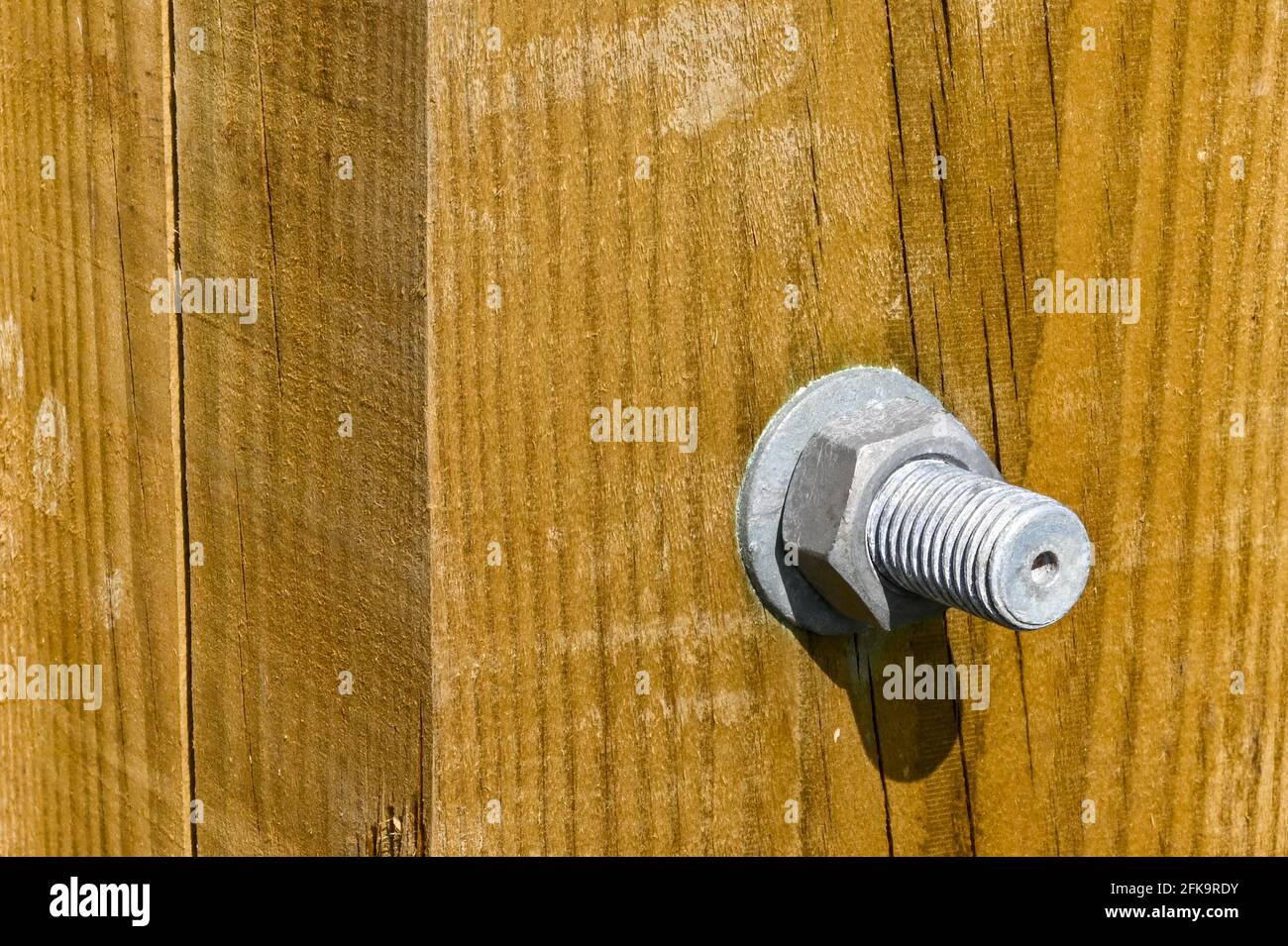 Close up view of a large metal nut and bolt fixing in a heavy wooden ...