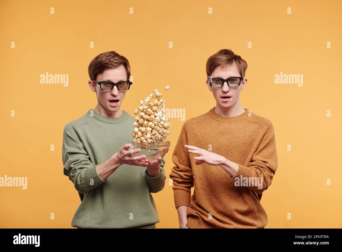 Portrait of shocked young twin brothers in 3D goggles ready to watch ...