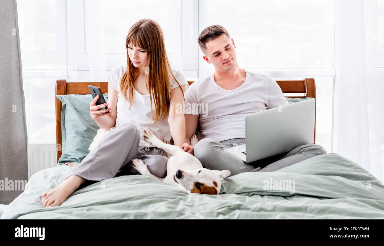 Couple in the bed with gadgets Stock Photo - Alamy