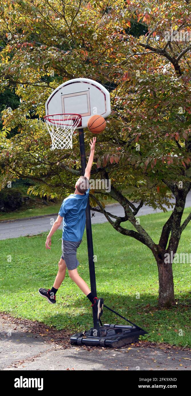 Teen boy shooting basketball hi-res stock photography and images - Alamy