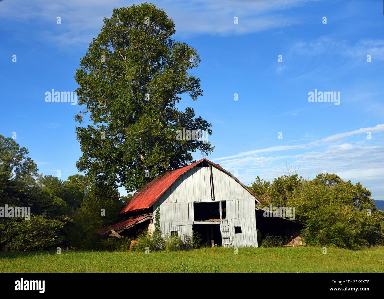 Sitting in the Blue Ridge Mountains, this white barn has red roof and ...