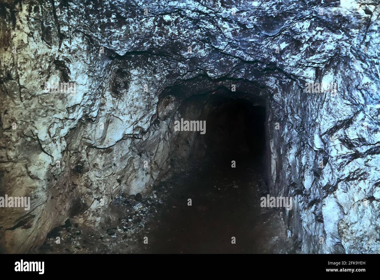 An old flooded mine, an underground corridor, and walls covered with ...