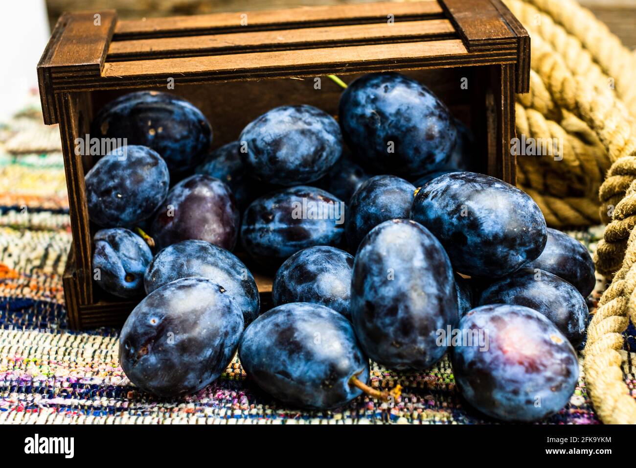 Ripe blue plums in a wooden crate in a rustic composition Stock Photo ...