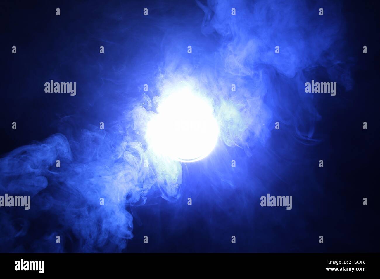 Artificial smoke is illuminated with blue bright light Stock Photo - Alamy