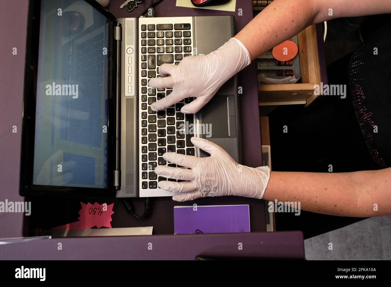 Hands with gloves working on laptop Stock Photo - Alamy