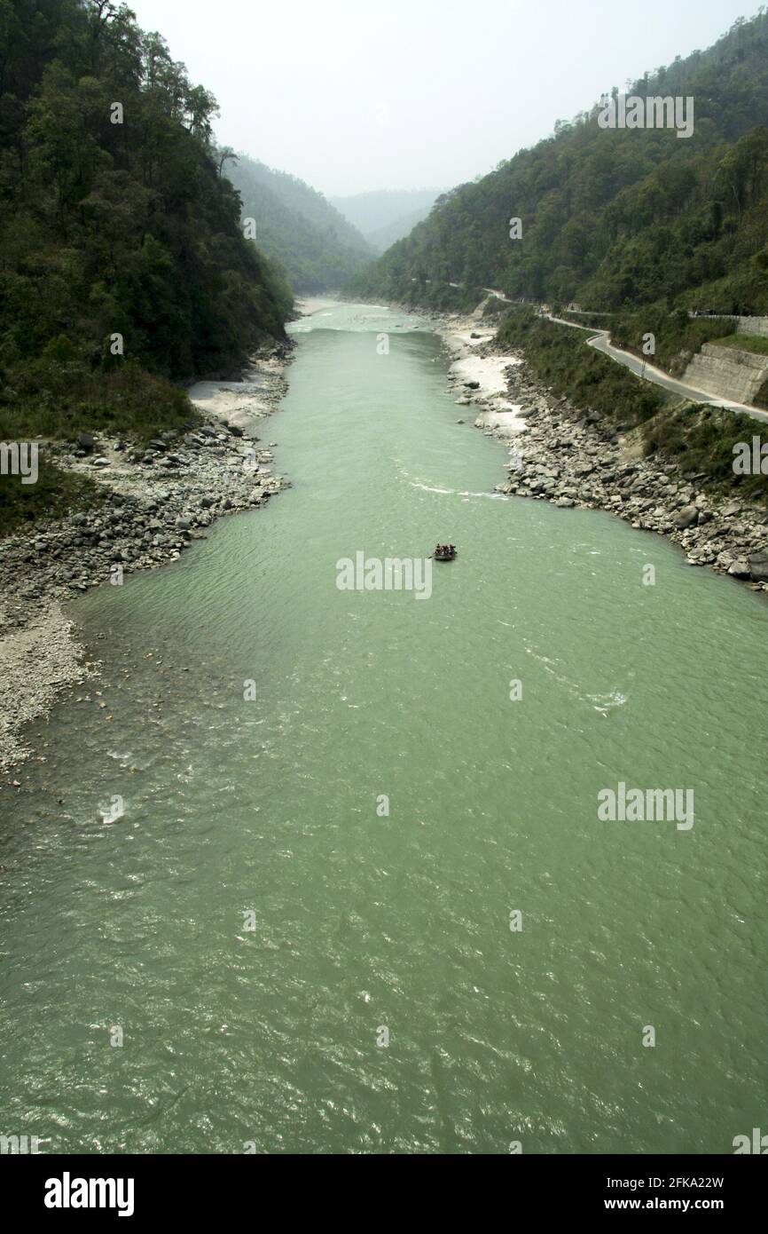 Vertical shot of a river flowing between mountains covered by rich ...
