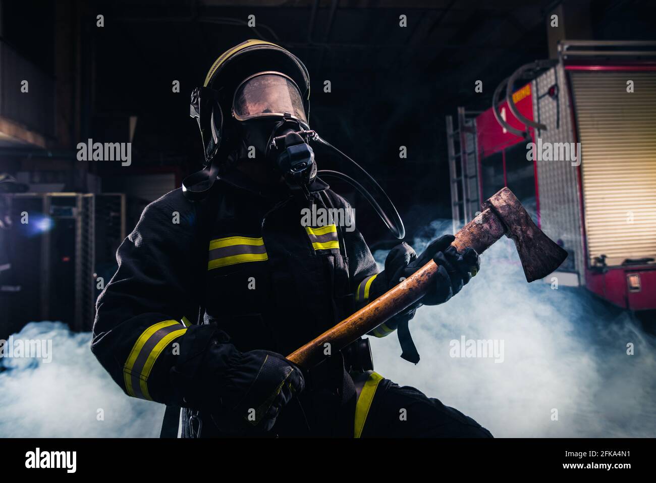 Portrait of a female firefighter while holding an axe and wearing an ...