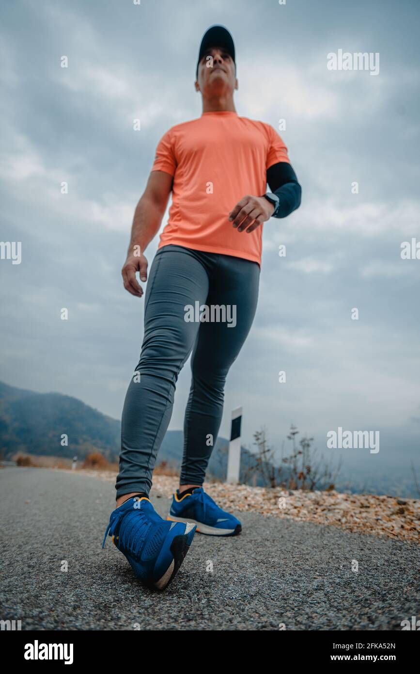 Healthy fit middle aged runner during a warm up routine before running ...