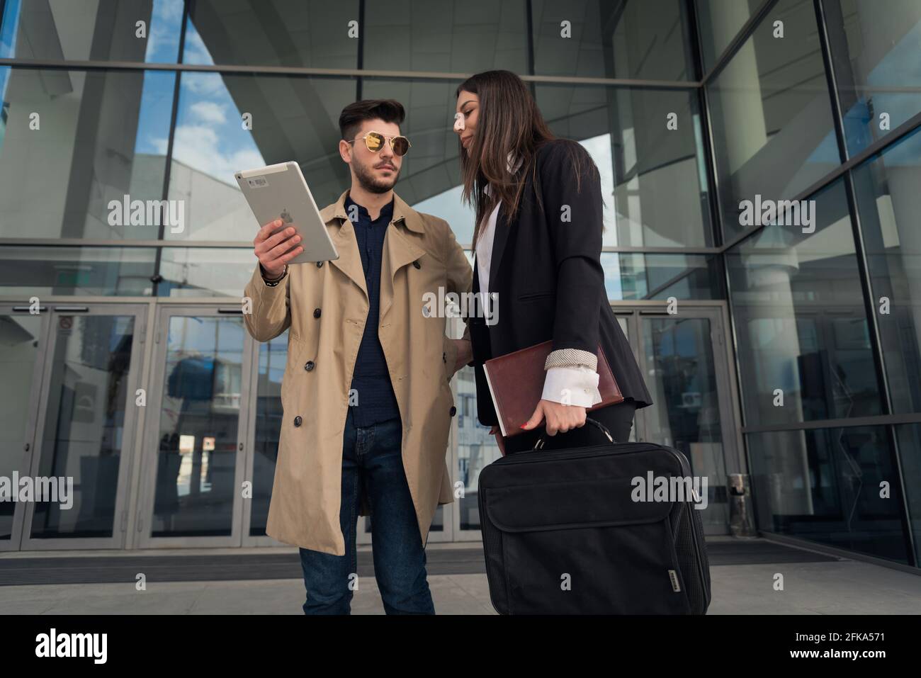 Well suited business people are looking at the tablet Stock Photo - Alamy