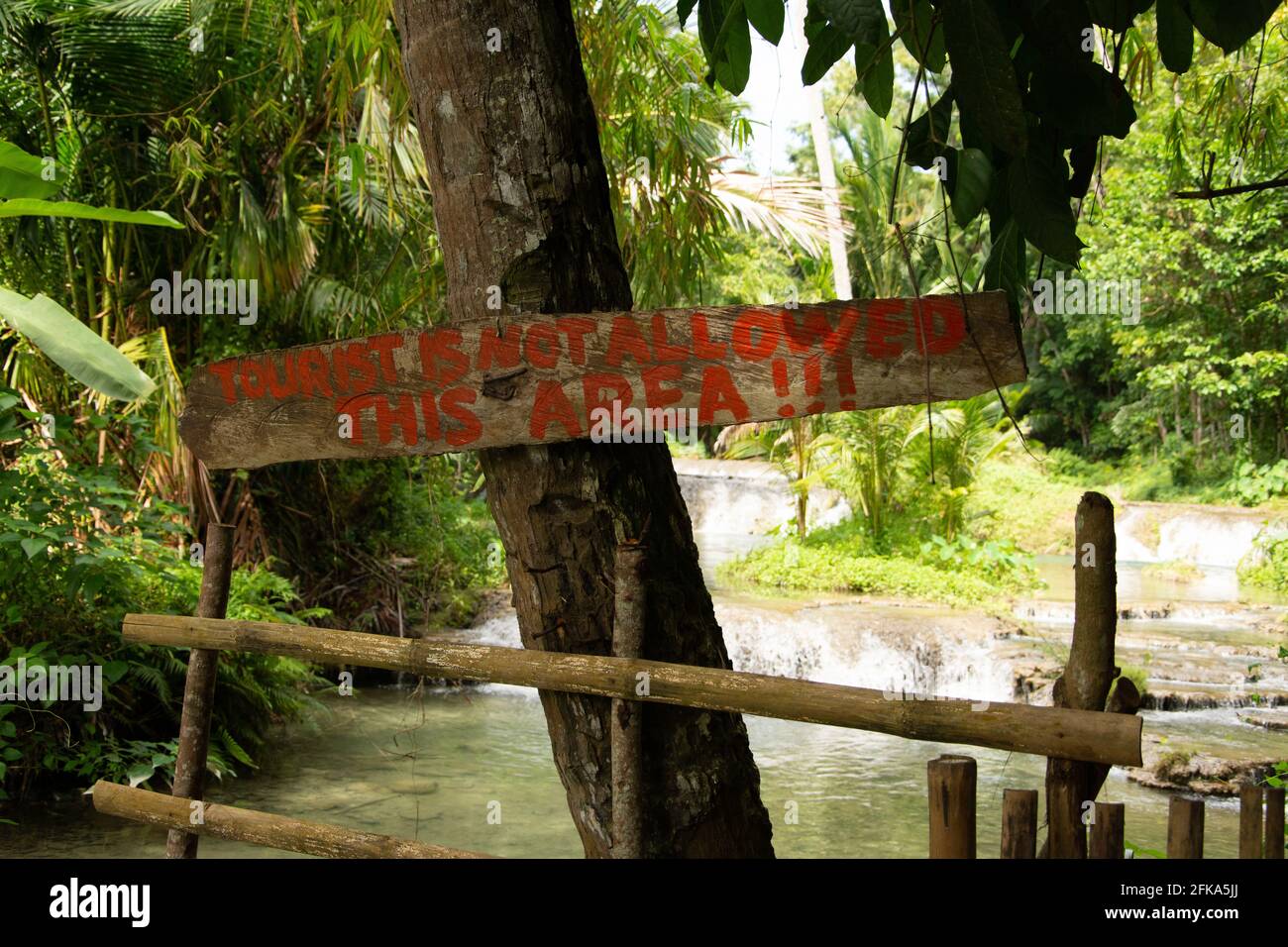 Big wooden warning sign board nailed to a tree banning tourists to ...